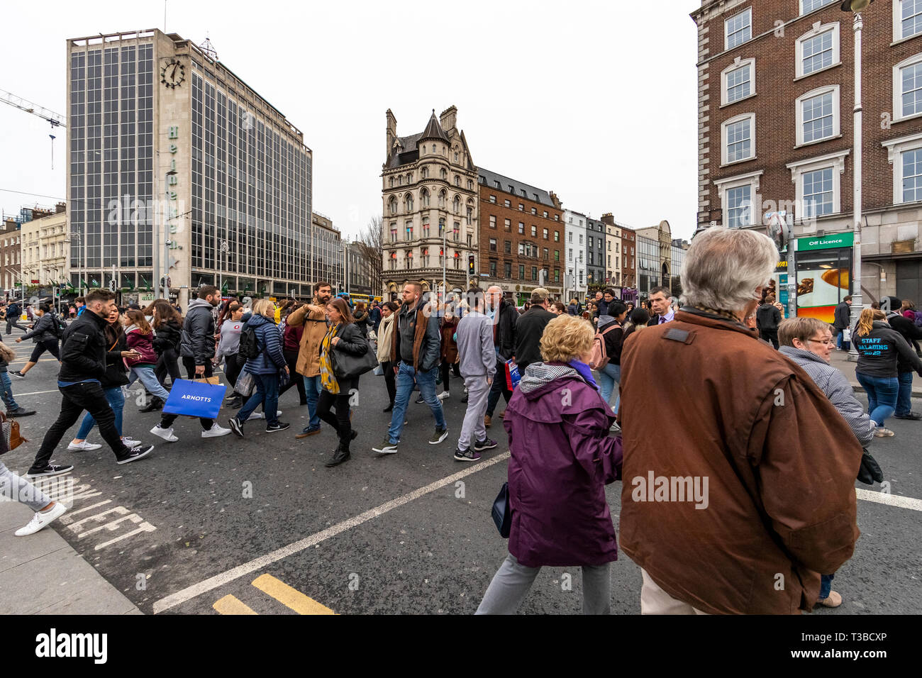 Crowds in the city centre cross at an intersection crossing. Dublin ...
