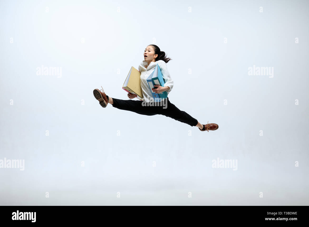 Hurry up, time is out. Worrying woman working at office, jumping and ...