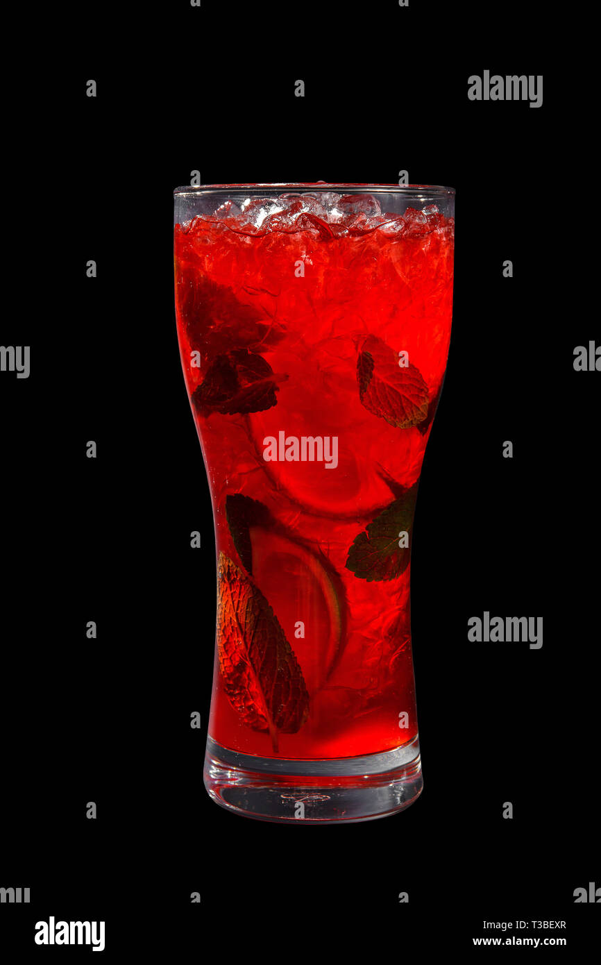 A single-colored, red cocktail in a tall glass with fine ice and lemon ...