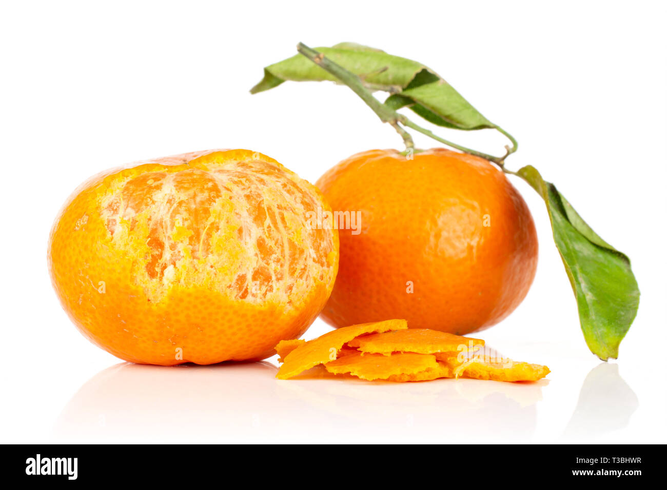 Group of two whole fresh orange mandarine rind pieces around with green ...