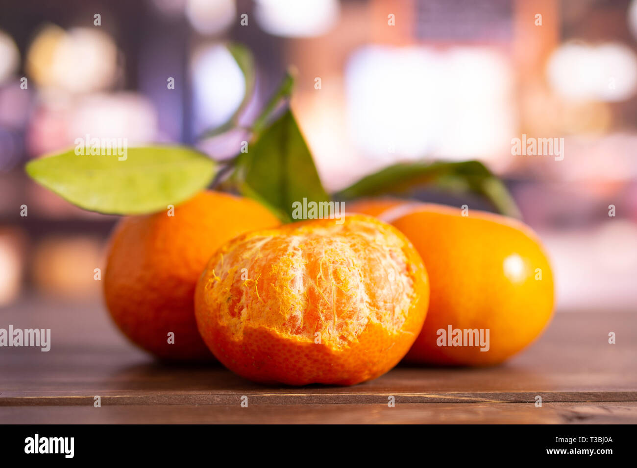 Group of three whole fresh orange mandarine with green leaves one fruit ...