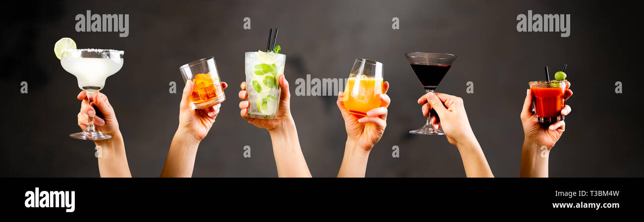 Hands holding classic cocktails on rustic background Stock Photo - Alamy