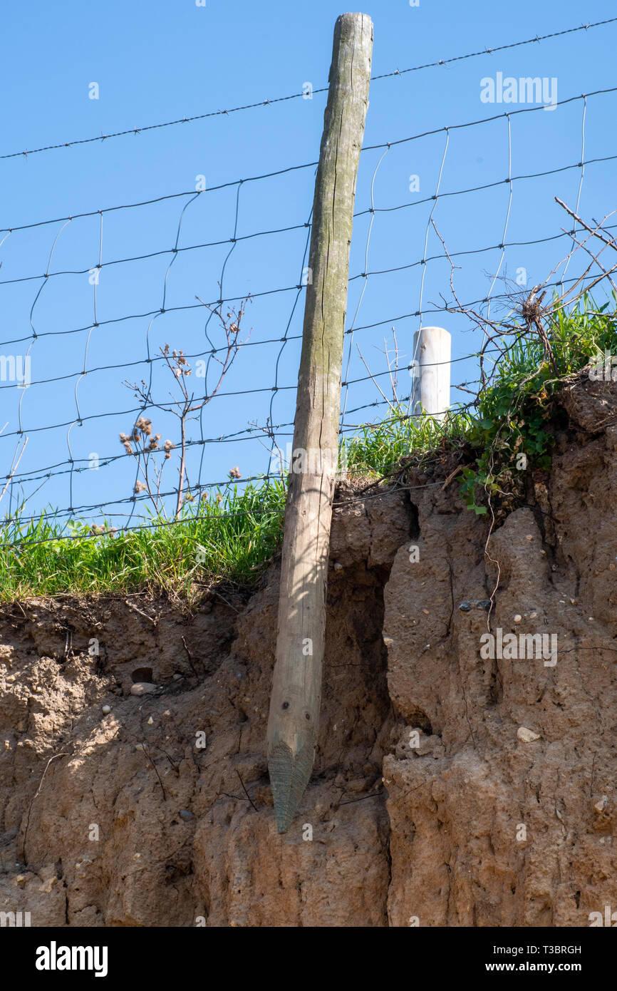 Exposed fence post on coastal path as a result of sea erosion Stock ...