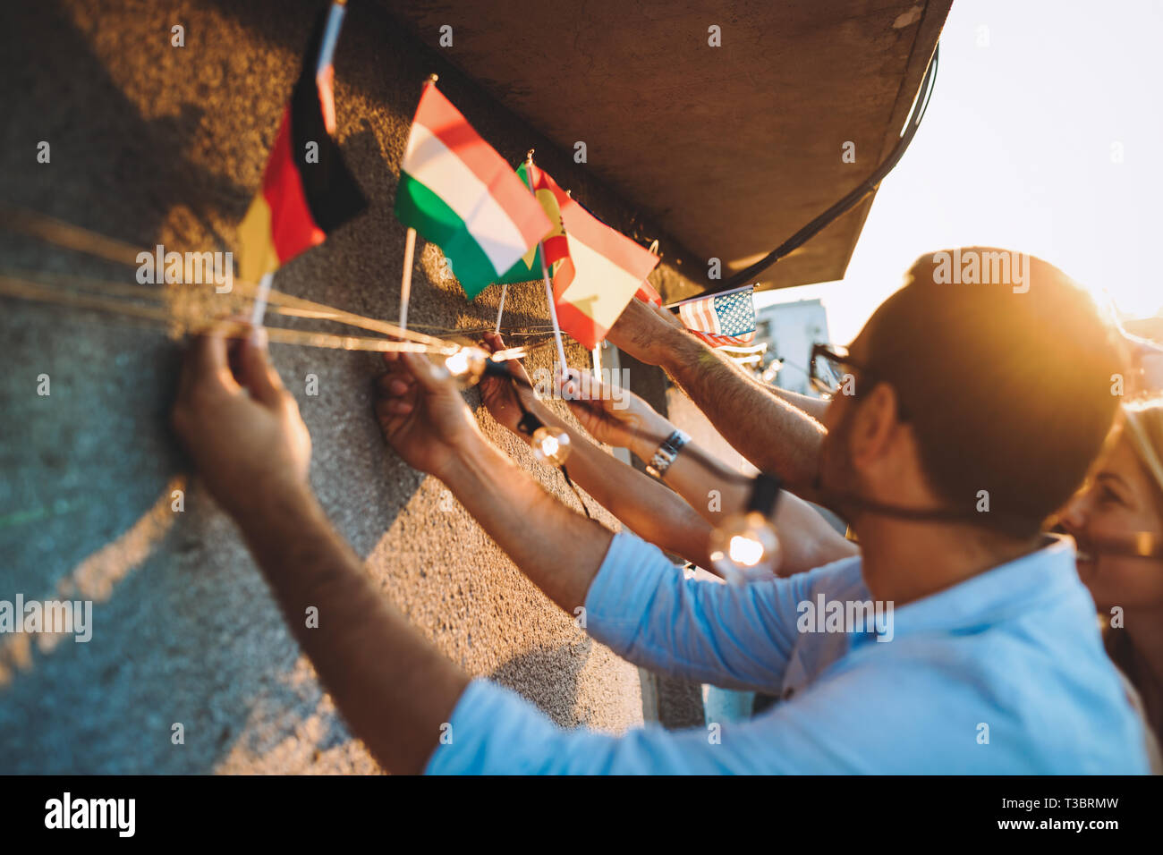 Group of friends placing international flasgs on wall Stock Photo - Alamy