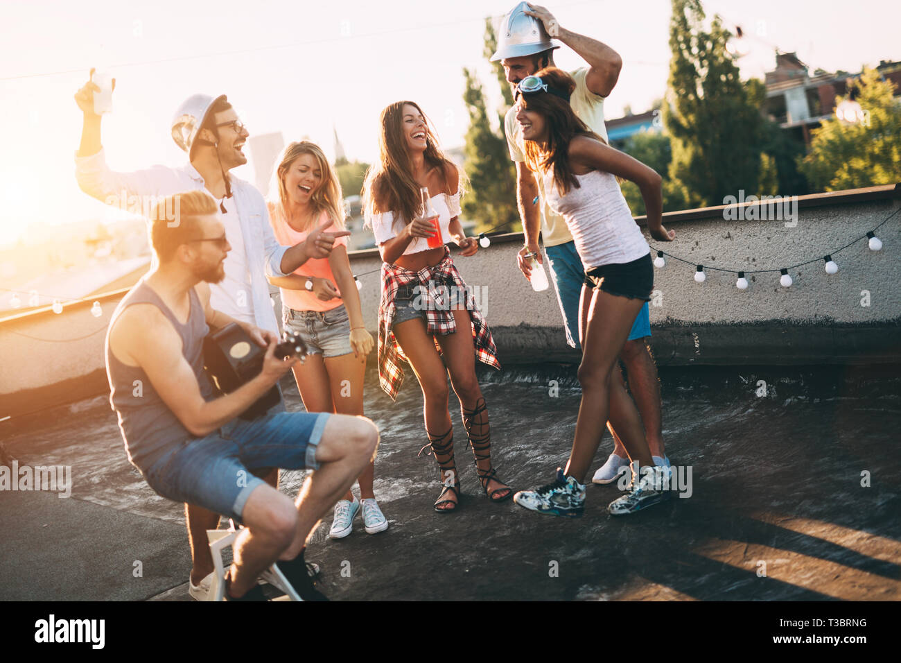Group of happy friends having party on rooftop Stock Photo - Alamy