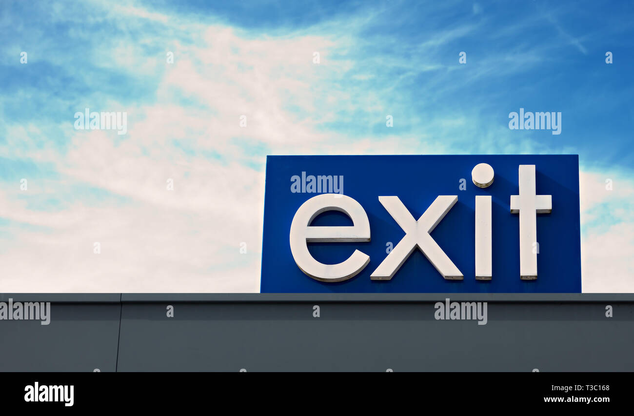 Blue store exit sign against a blue sky Stock Photo - Alamy