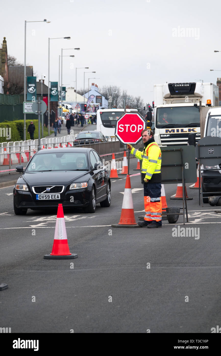 Workmen manually controlling traffic with stop and go signs Stock Photo ...