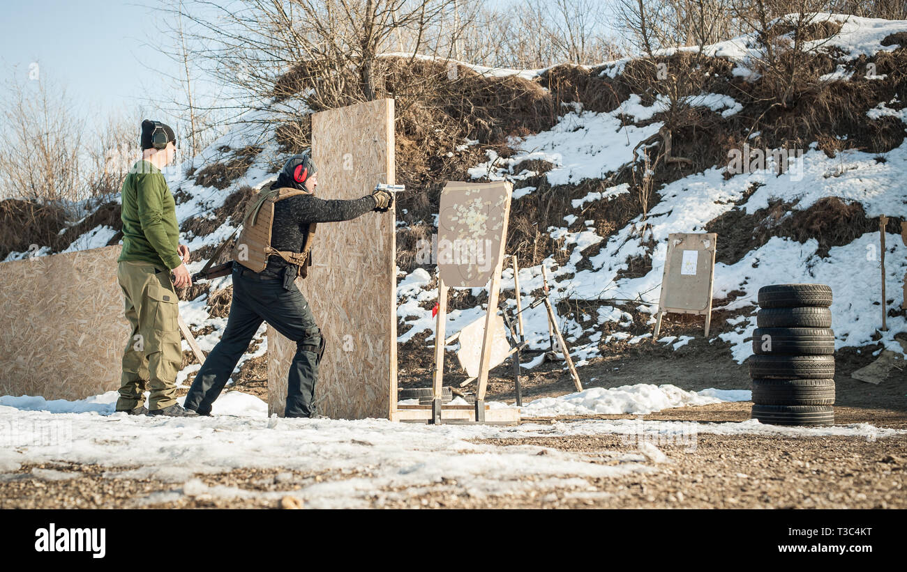 Instructor on shooting range teaches his student tactical gun shooting ...