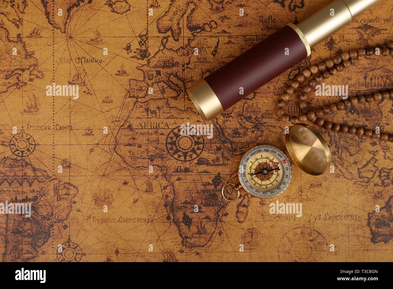 Vintage compass and spyglass on old world map - adventure stories ...