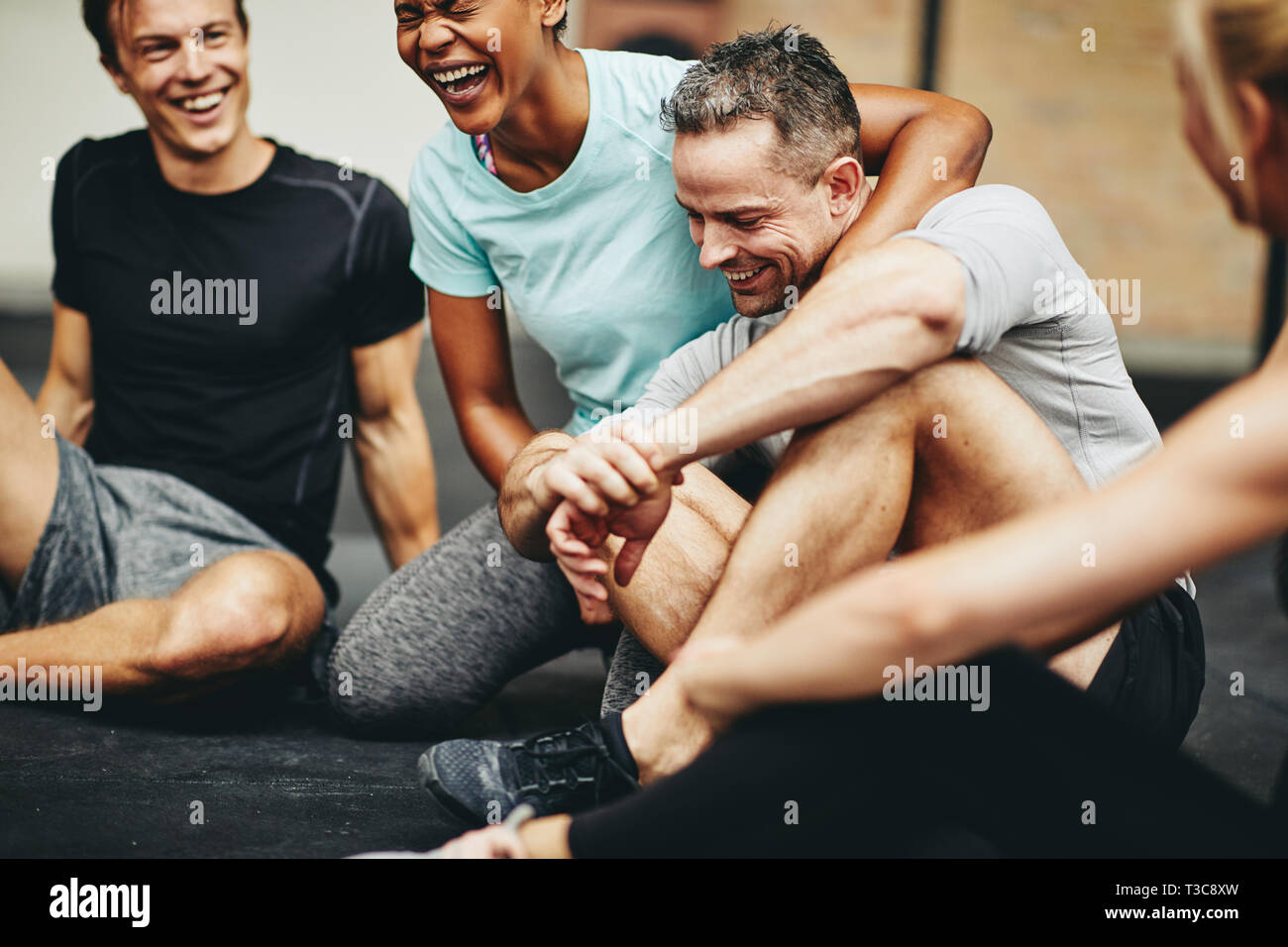 Group of diverse friends in sportswear laughing and messing around ...