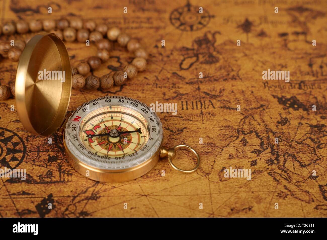Vintage Compass lies on an ancient world map - adventure stories ...