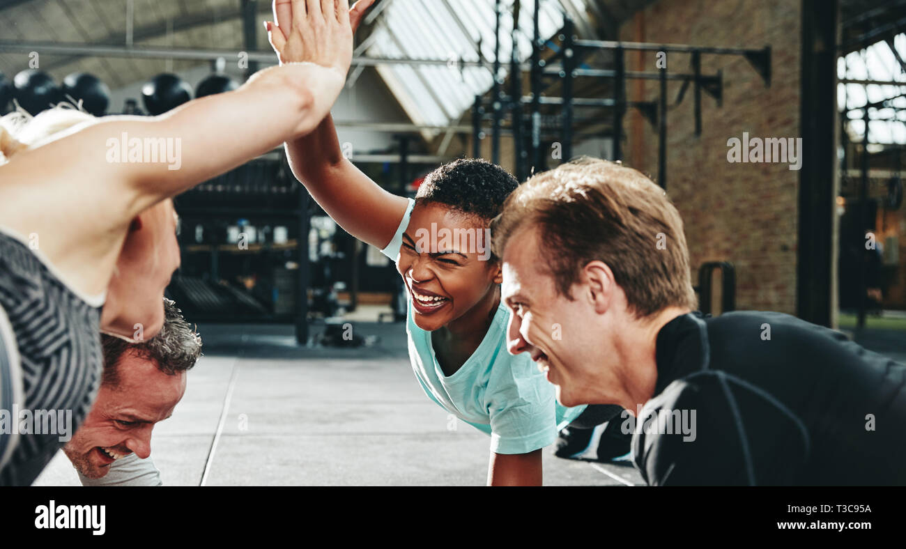 Two laughing young women in sportswear high fiving each other while ...