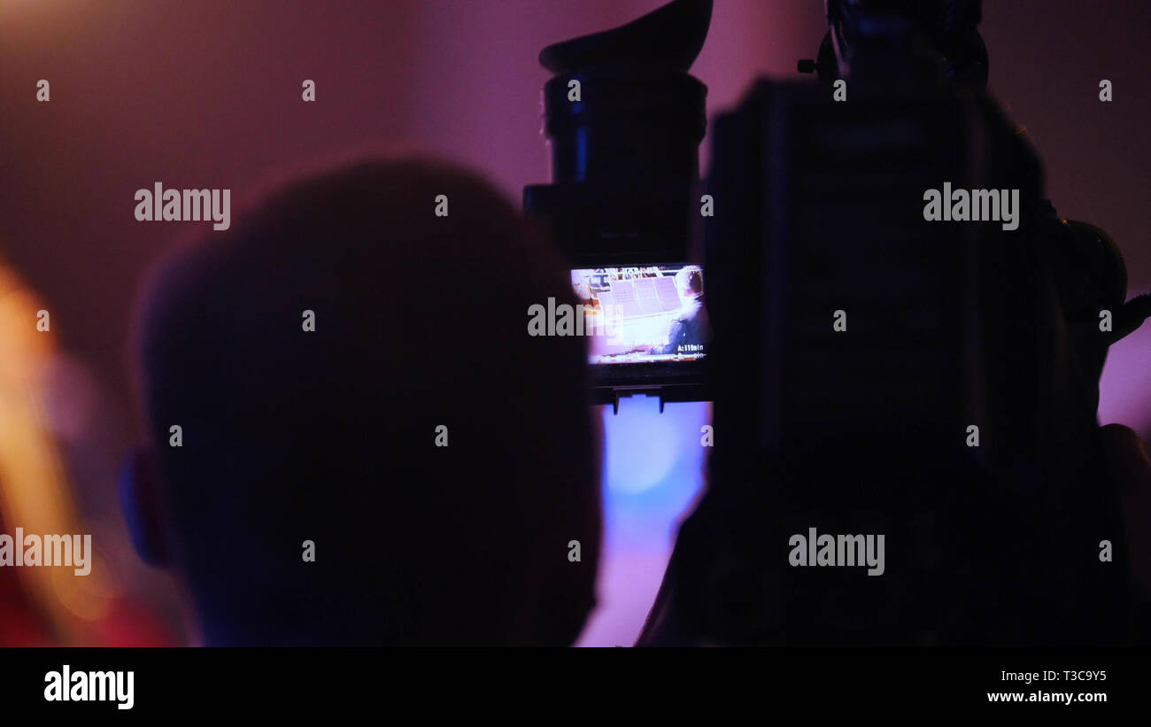 Cameraman filming the piano performance in colorful lights Stock Photo ...