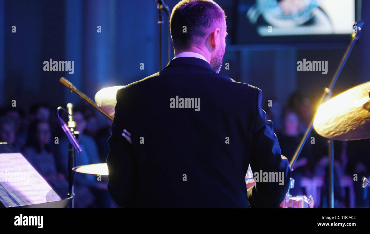 A man in costume playing drums at the jazz concert. Back view Stock ...