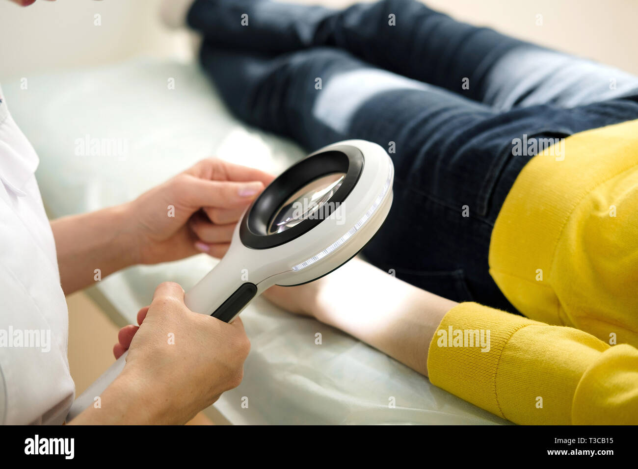 Dermatologist using a professional magnifying glass while doing skin ...