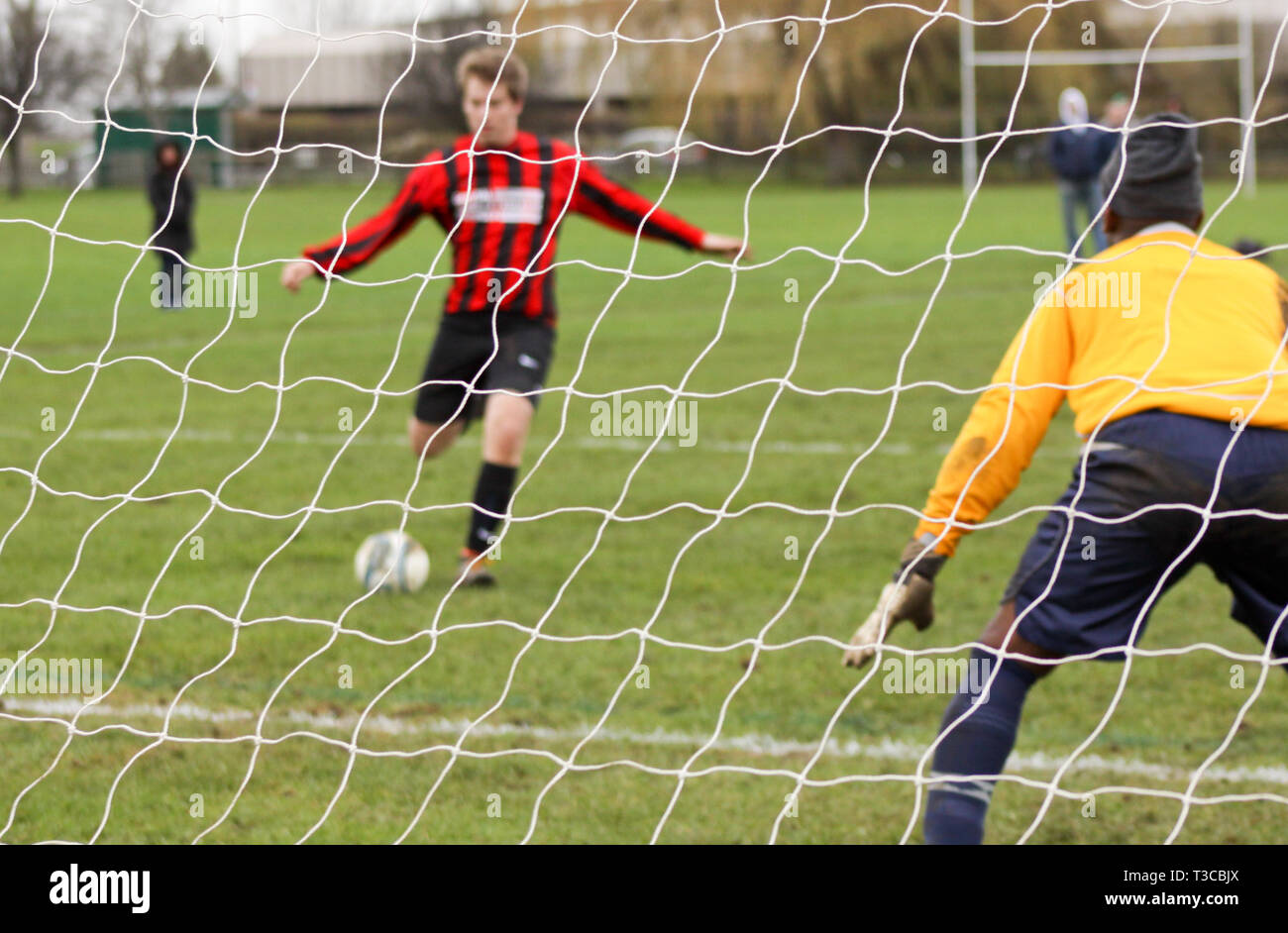 Footballer taking a shot at goal Stock Photo - Alamy