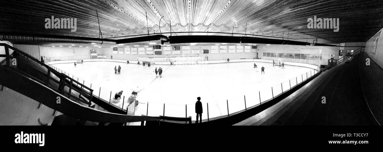 A panorama fisheye view of an indoor hockey rink with a few players on ...