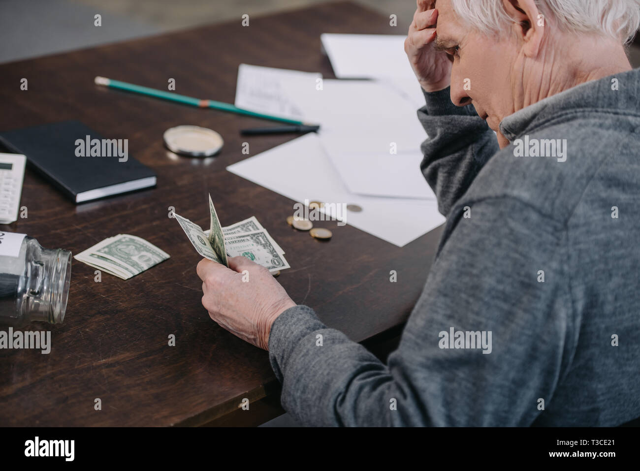 Senior man counting money table hi-res stock photography and images - Alamy