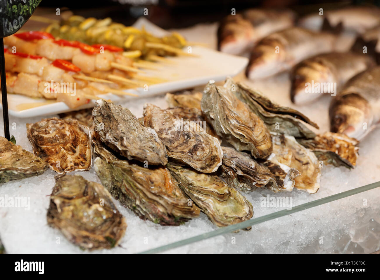 Oysters and fish on iced market display Stock Photo - Alamy