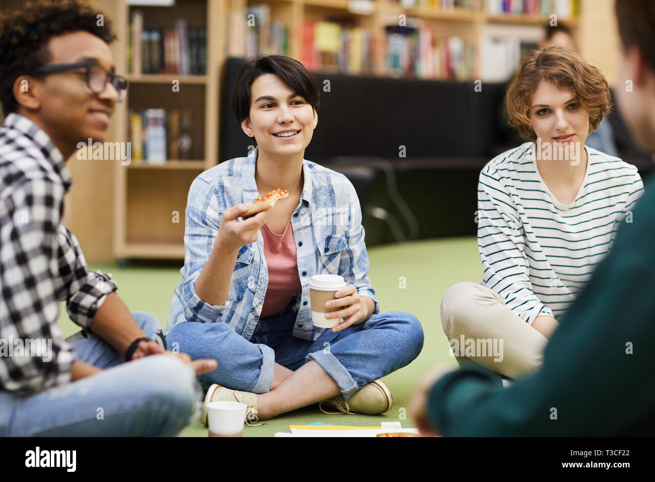 Positive students having lunch break in library Stock Photo - Alamy