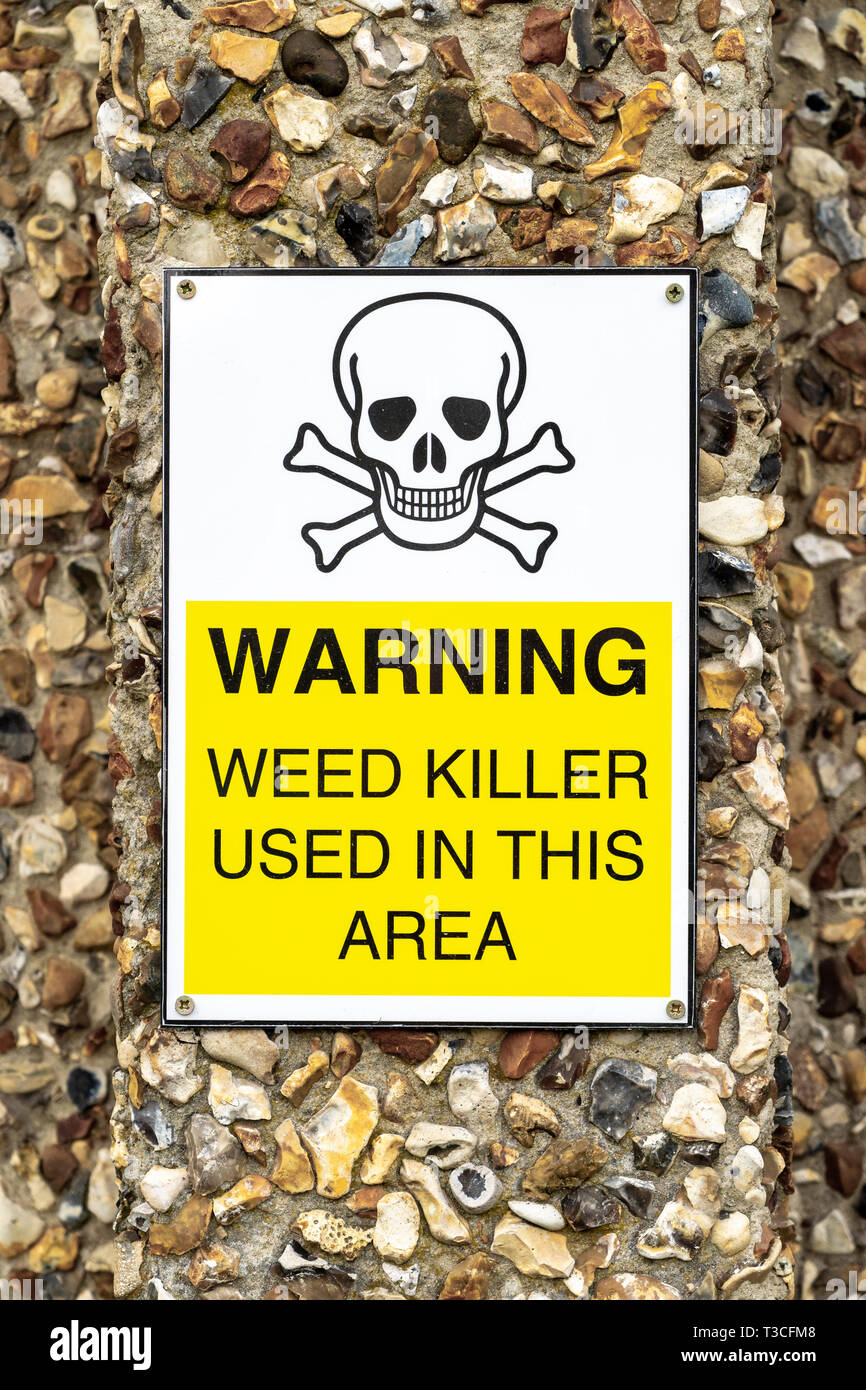 Weed killer usage warning sign attached to pebble dashed wall Stock ...