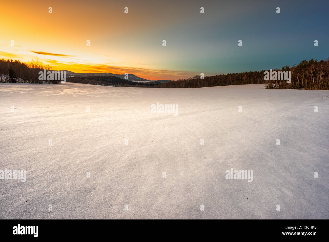 Snow plain under the orange sunset sky Stock Photo - Alamy