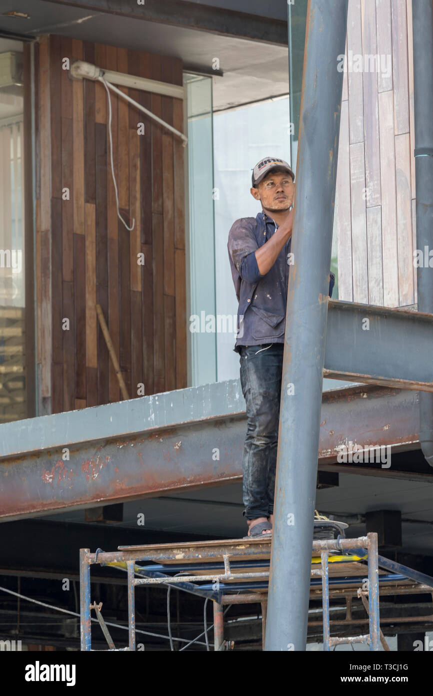 a worker working at height on a building site in phuket, thailand ...