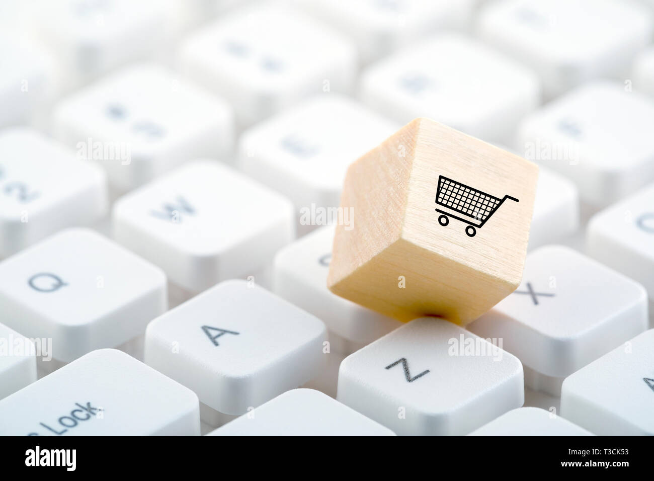 Wooden block with shopping cart graphic on computer keyboard. Online ...