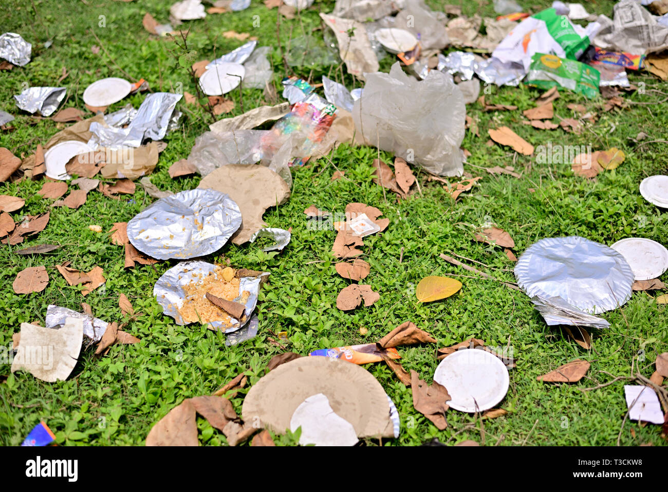 Waste Plastic packets are dumped on green field Stock Photo - Alamy