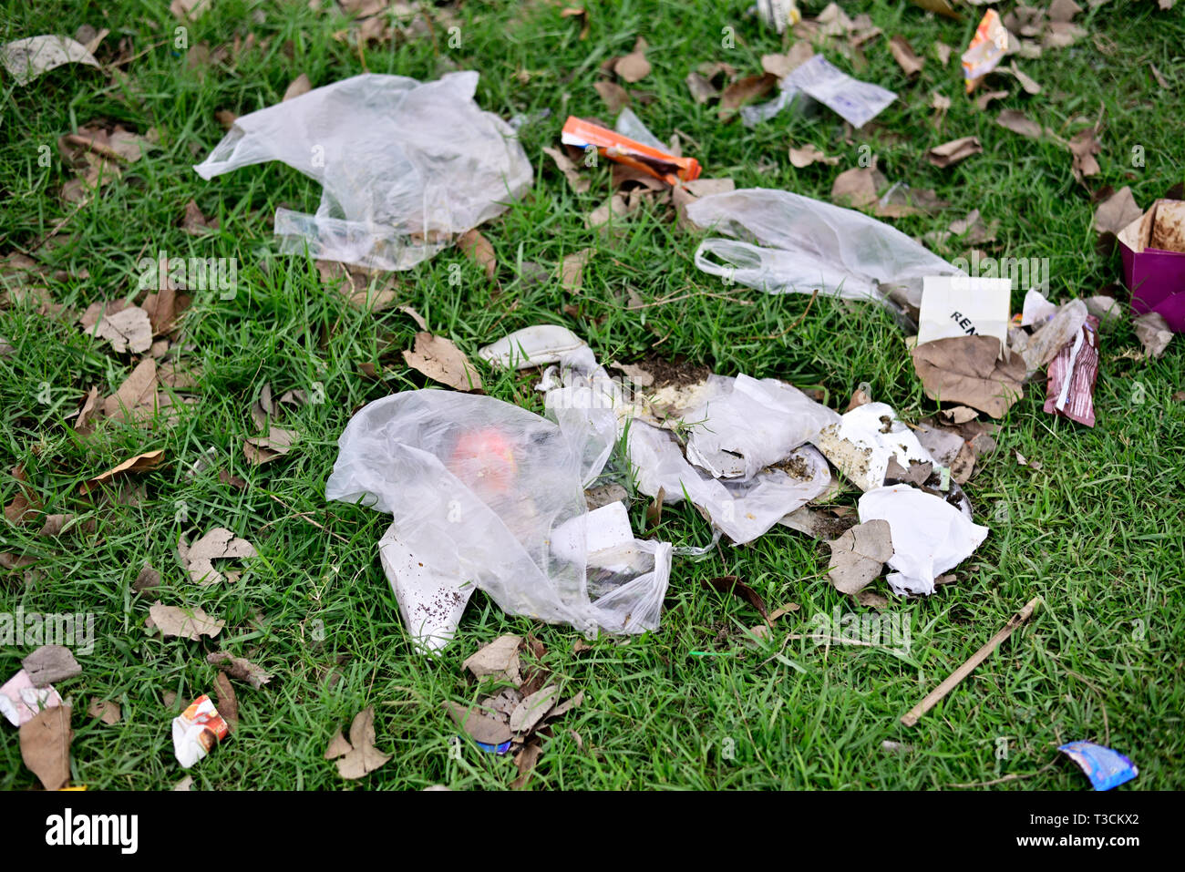 Waste Plastic packets are dumped on green field Stock Photo - Alamy