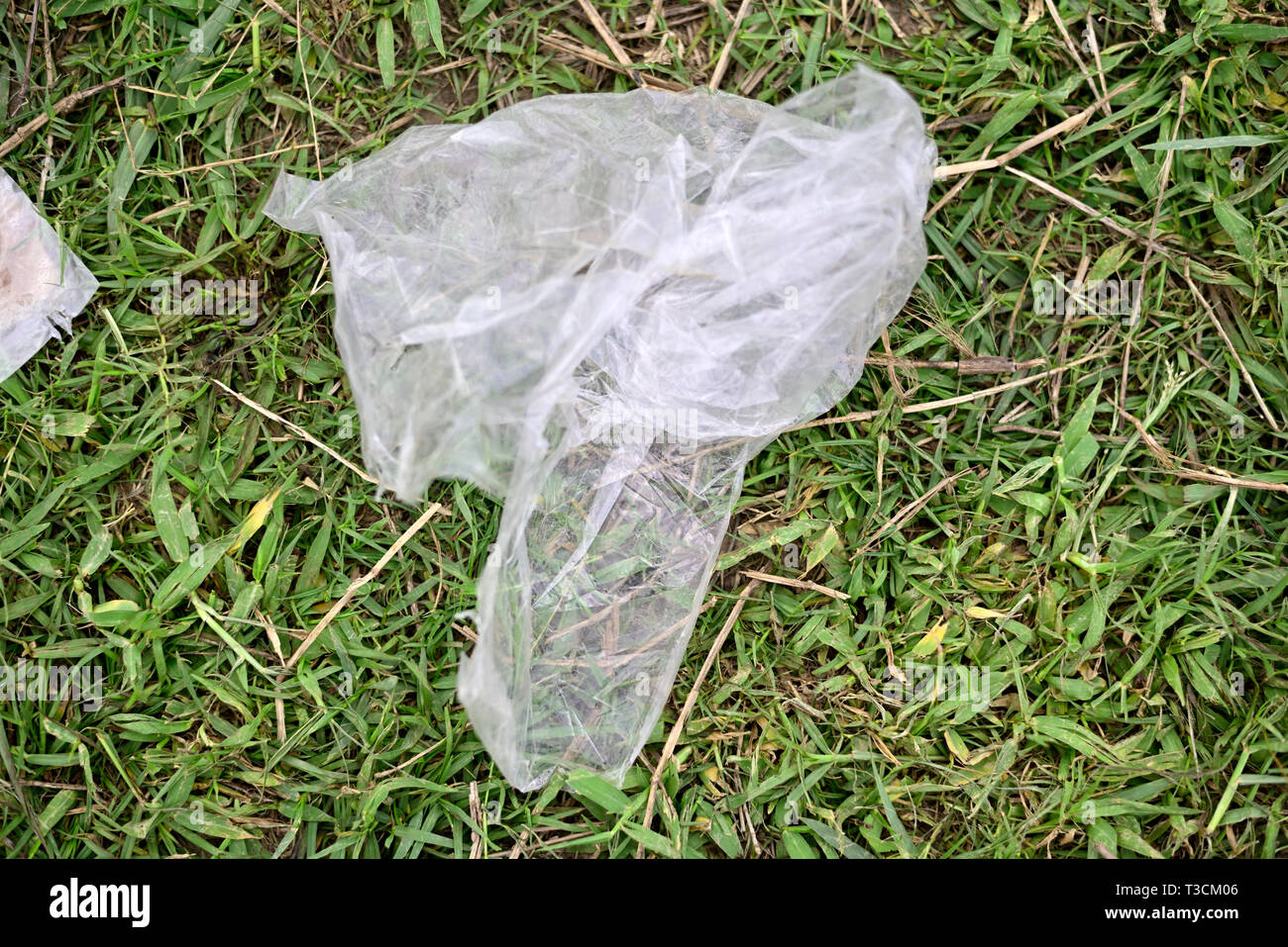 Waste Plastic packets are dumped on green grass field Stock Photo - Alamy