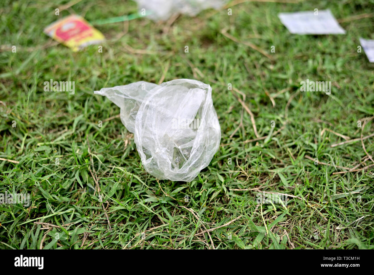 Waste Plastic packets are dumped on green grass field Stock Photo - Alamy