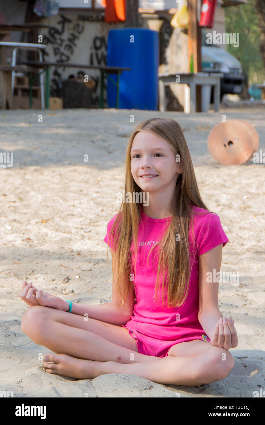Young athletic girl makes gymnastic figures on the beach Stock Photo ...