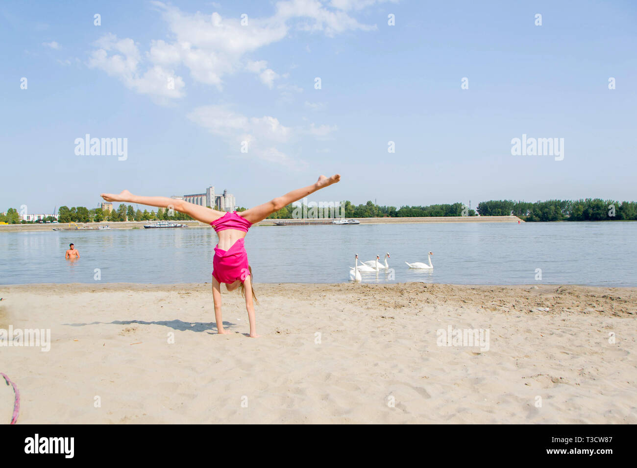 Young athletic girl makes gymnastic figures on the beach Stock Photo ...