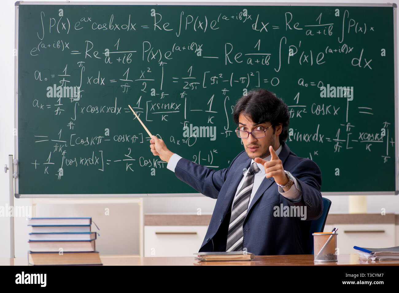 Young male math teacher in classroom Stock Photo - Alamy