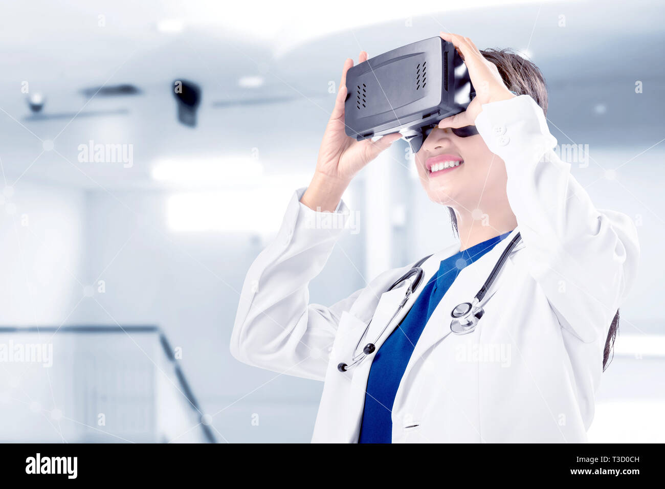 Asian female doctor in white coat and stethoscope using virtual reality ...