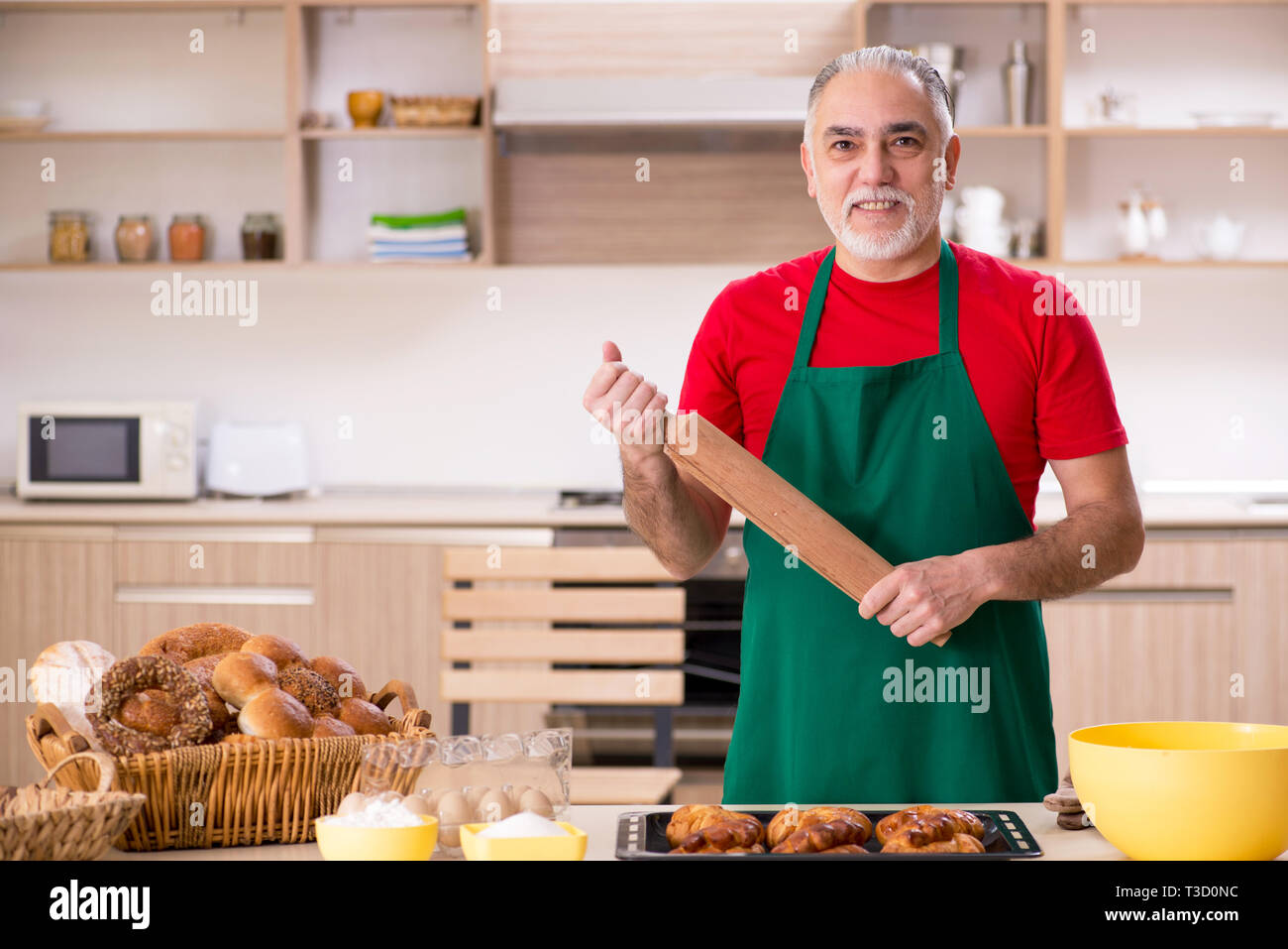 Old male baker working in the kitchen Stock Photo - Alamy
