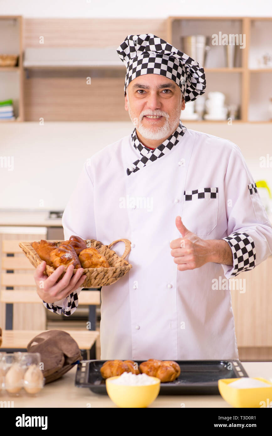 Old male baker working in the kitchen Stock Photo - Alamy