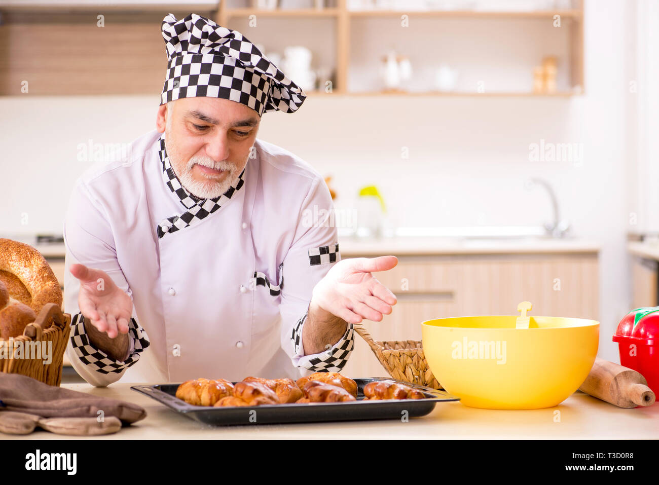 Old male baker working in the kitchen Stock Photo - Alamy