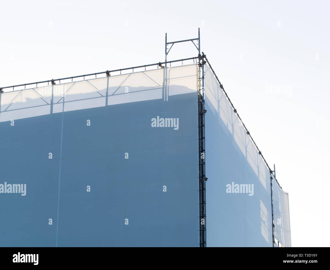 covered scaffolding protects a building under restoration, white sky ...