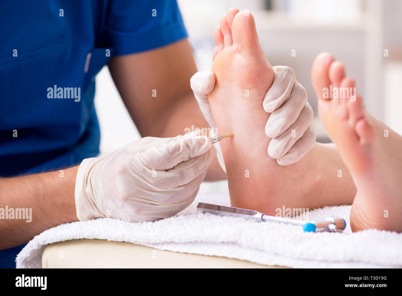 Podiatrist treating feet during procedure Stock Photo - Alamy