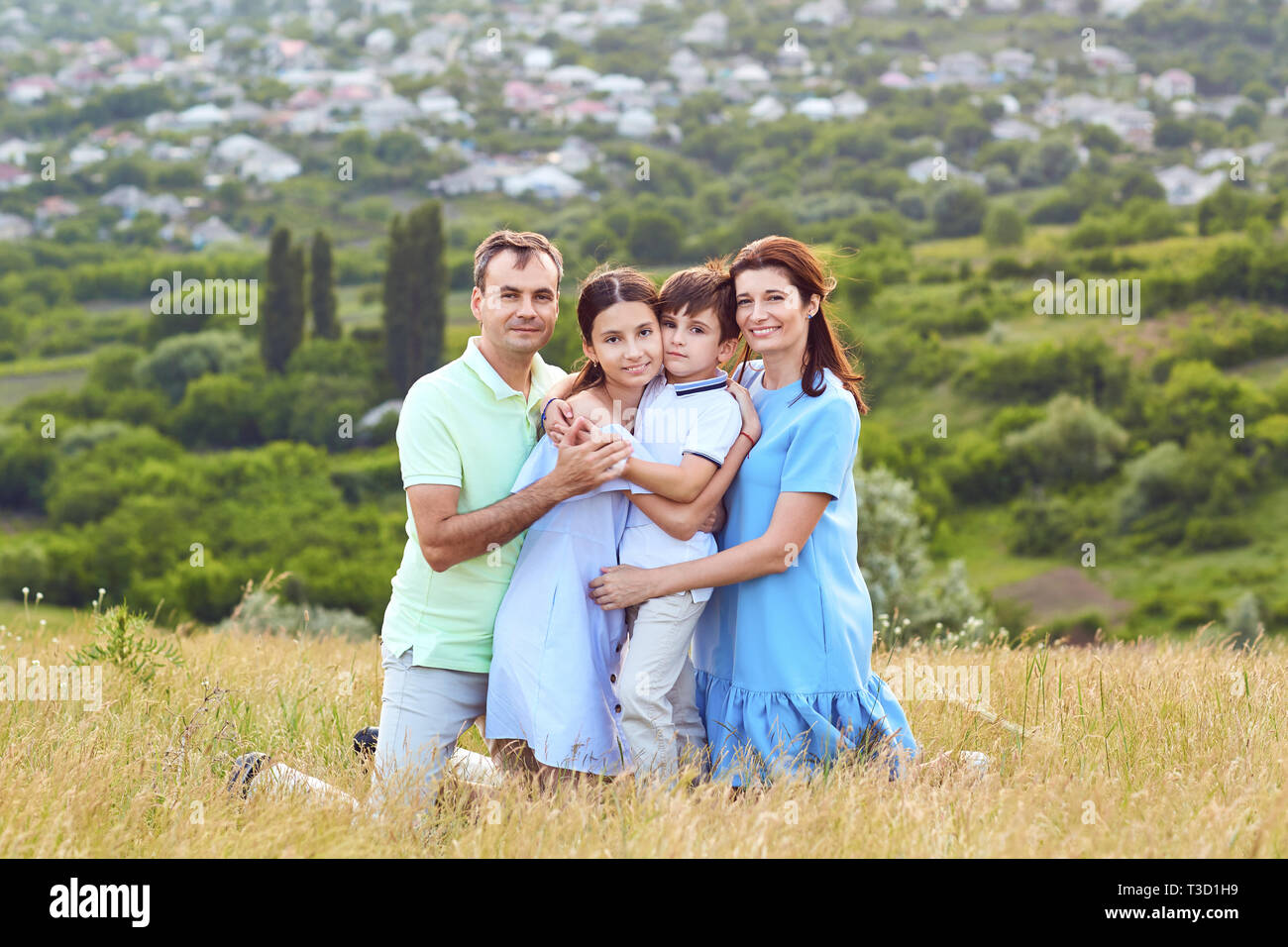 Portrait of a happy family sitting on nature Stock Photo - Alamy