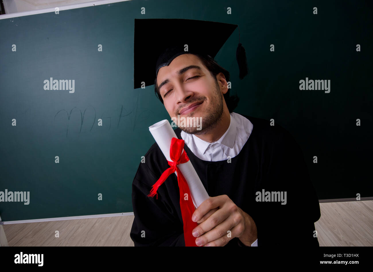 Graduate student in front of green board Stock Photo - Alamy