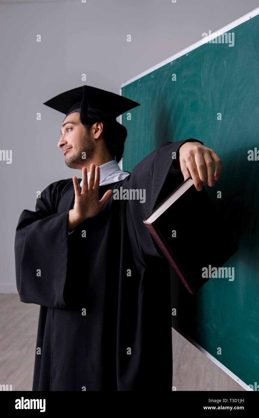 Graduate student in front of green board Stock Photo - Alamy