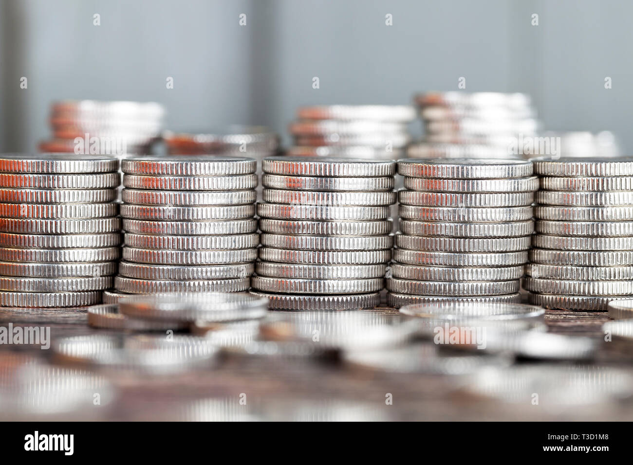 A stacked pile of beautiful silver coins with a ribbed uneven surface ...