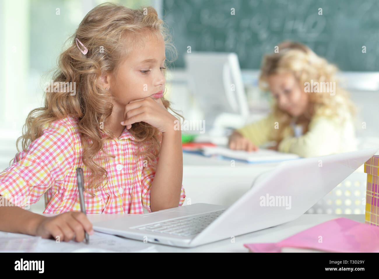two beautiful little girls working with computers Stock Photo - Alamy