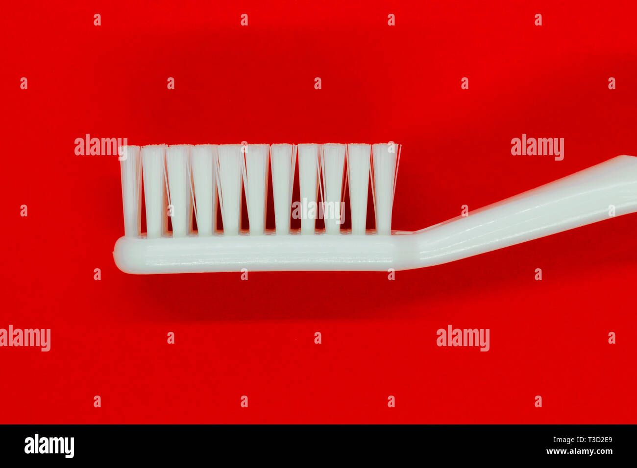 Side view of white toothbrush on red background Stock Photo - Alamy