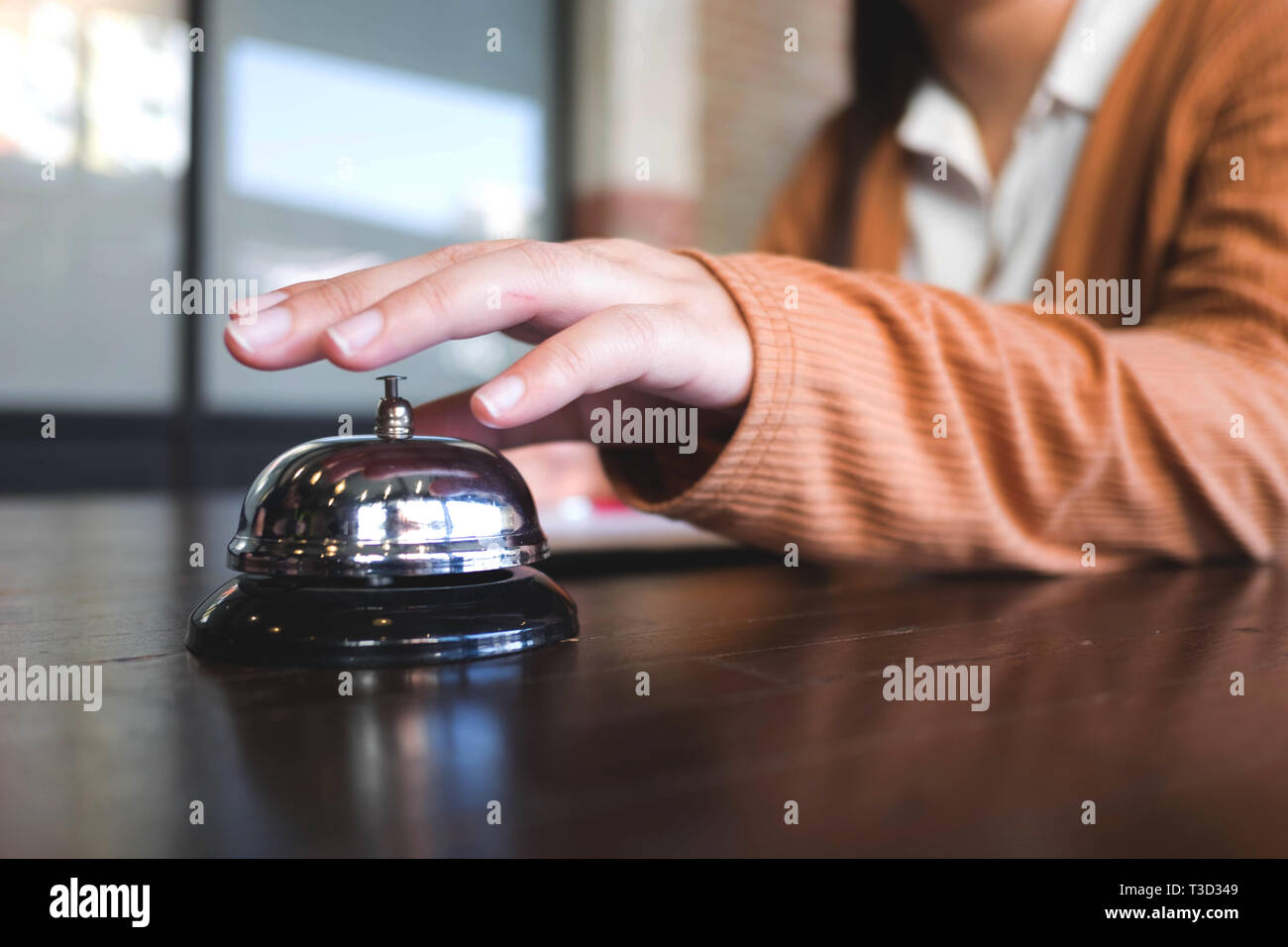 Women call hotel reception with finger push a bell in lobby hotel ...