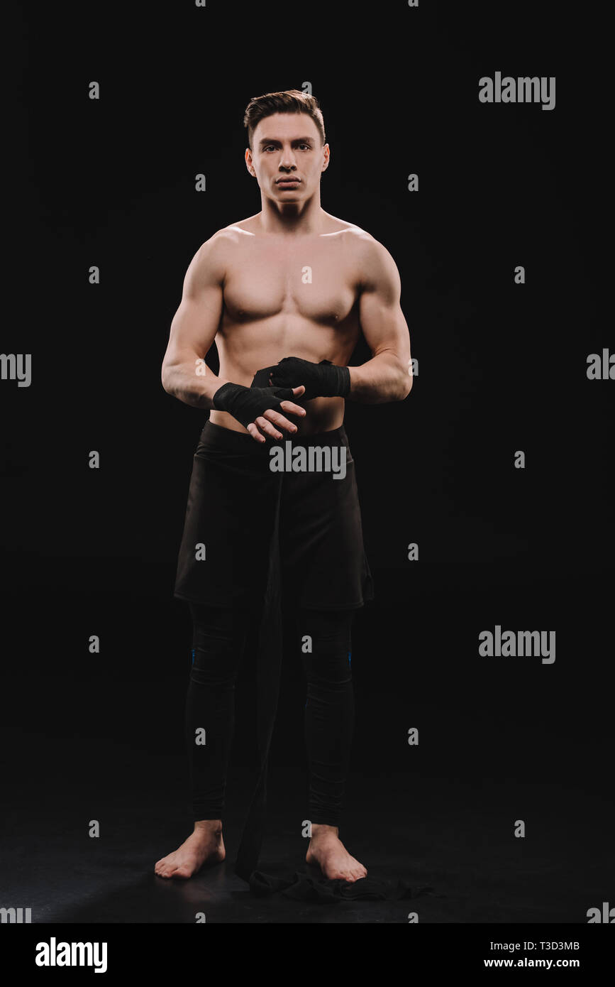 Strong Shirtless And Barefoot Muscular Mma Fighter Fixing Bandages And