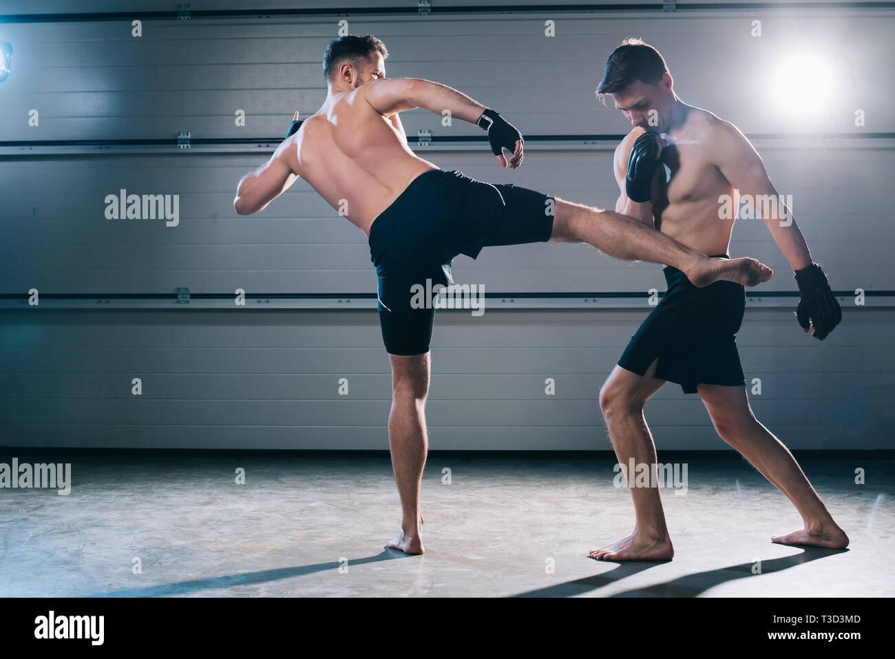back view of barefoot mma fighter kicking opponent with leg Stock Photo ...